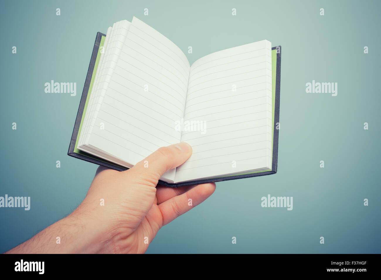 A hand is holding a small notebook Stock Photo - Alamy