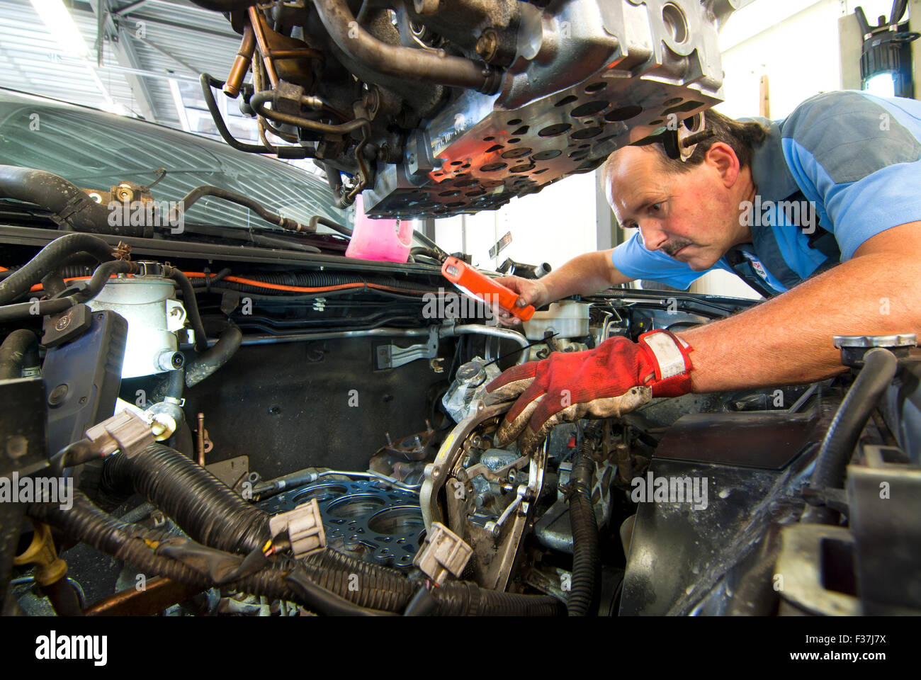 auto mechanic is at work with the replacement of the cylinder head of a ...