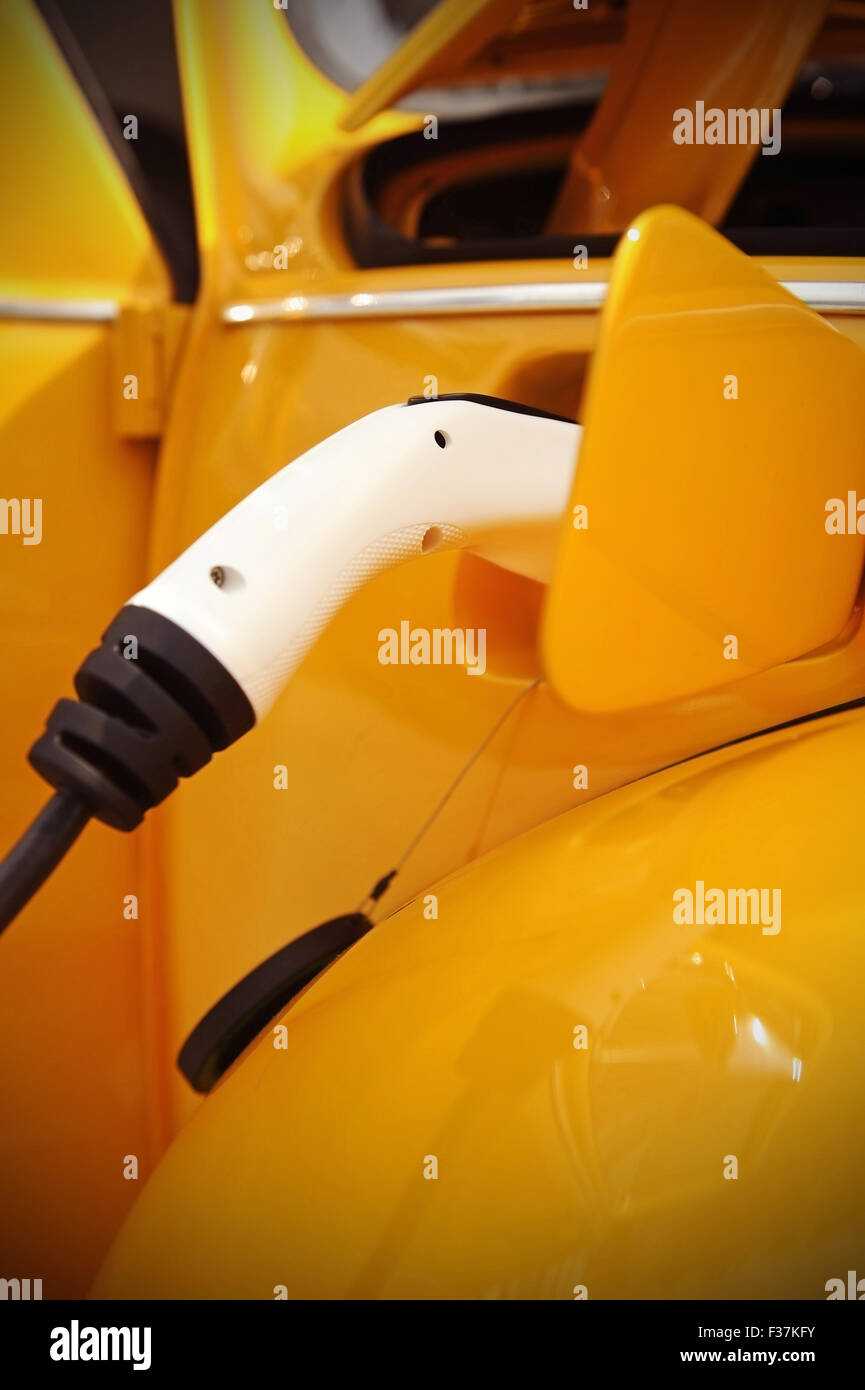 Vignetted shot with an electric plug in connected and charging a ...