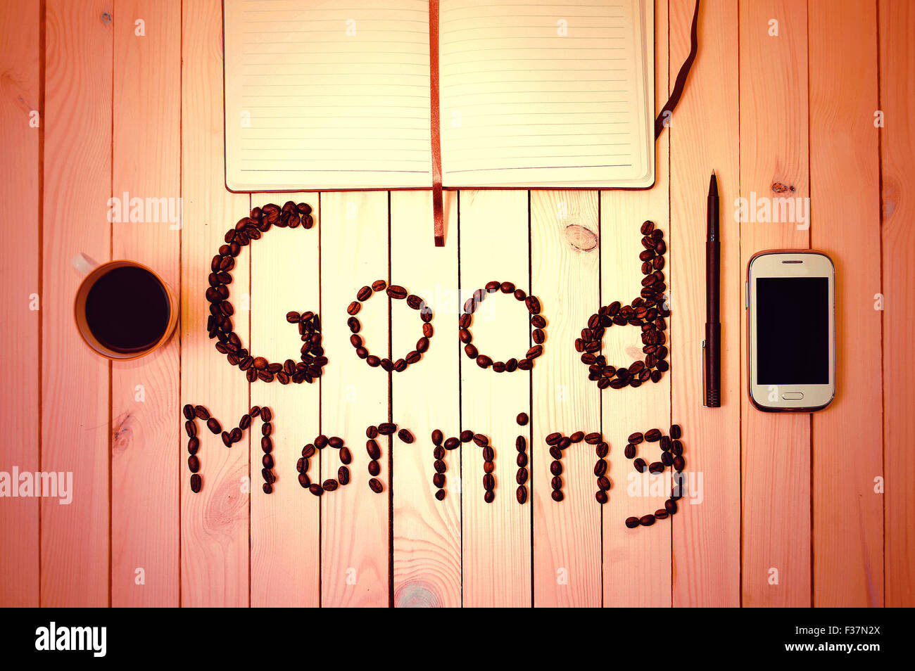 Good Morning inscription made with coffee beans between white cell ...