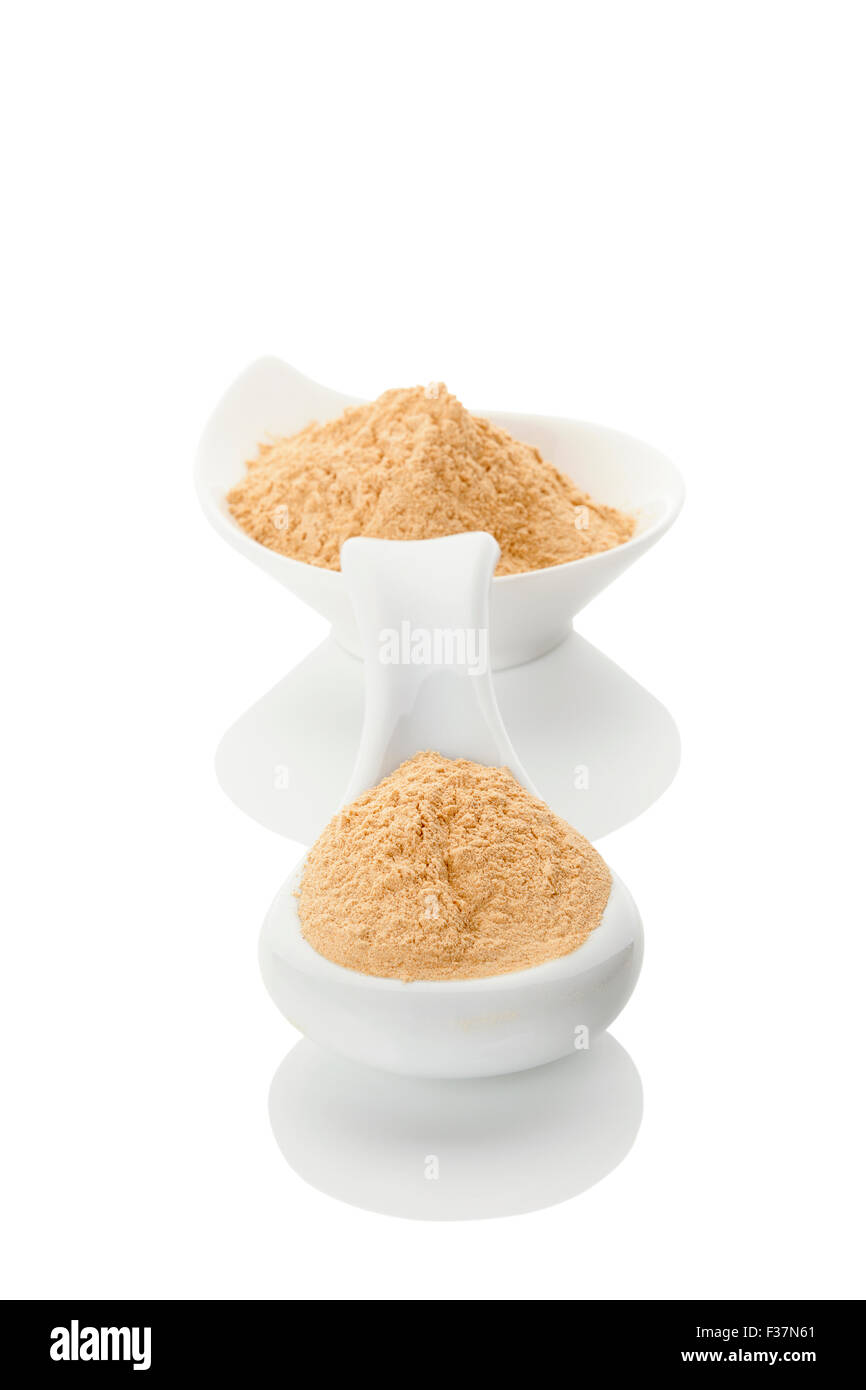 Maca powder on spoon and in a bowl isolated on white background ...