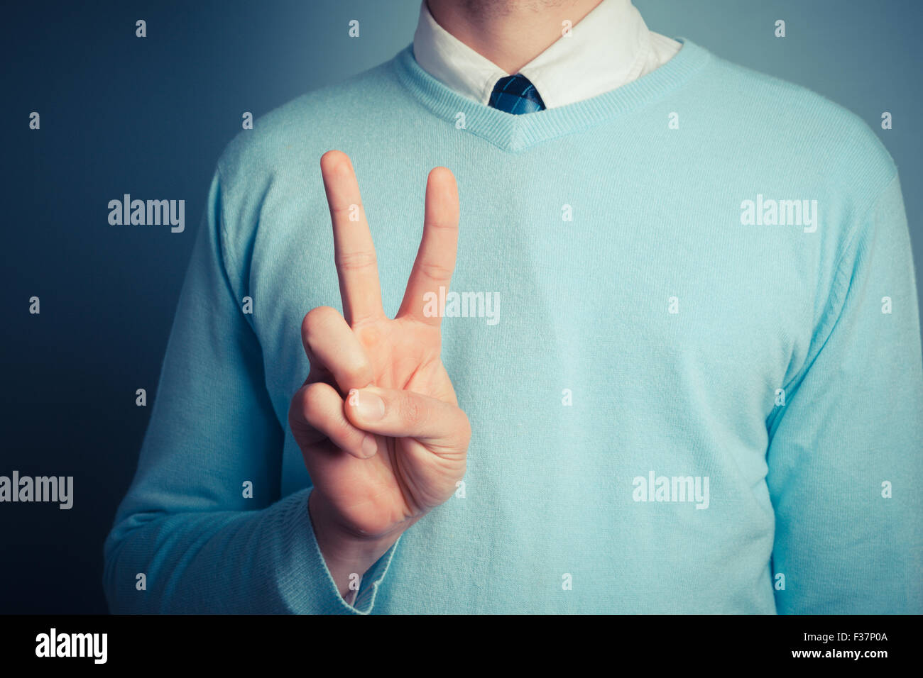 A young man is gesturing a peace sign Stock Photo - Alamy