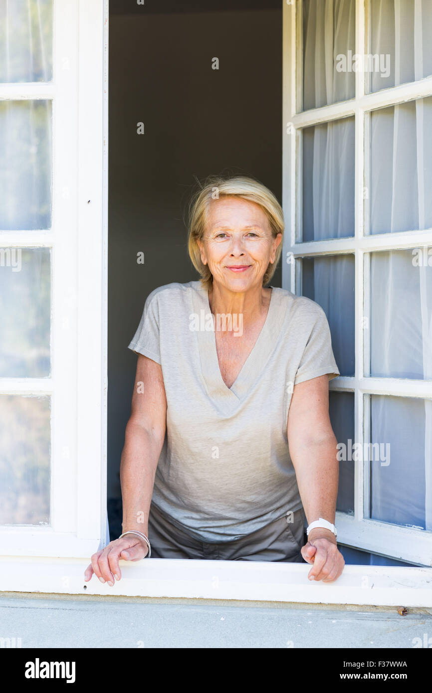 Woman opening window Stock Photo - Alamy