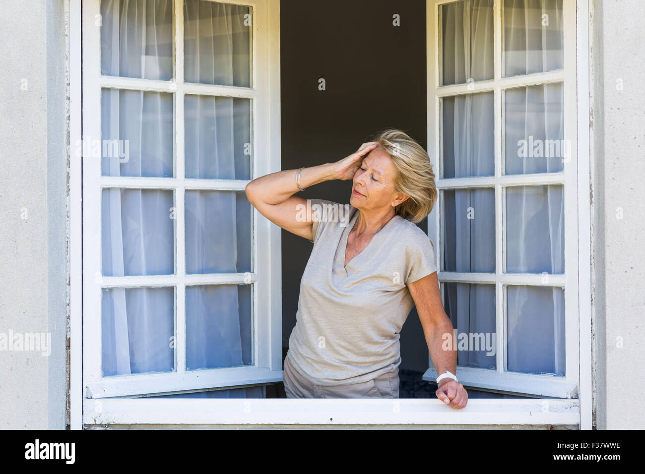Woman opening window Stock Photo - Alamy