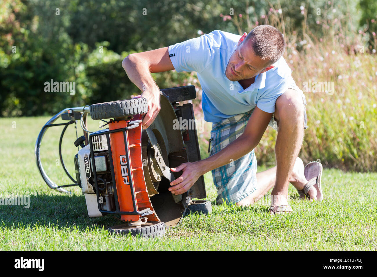 Man using a lawn mower Stock Photo - Alamy