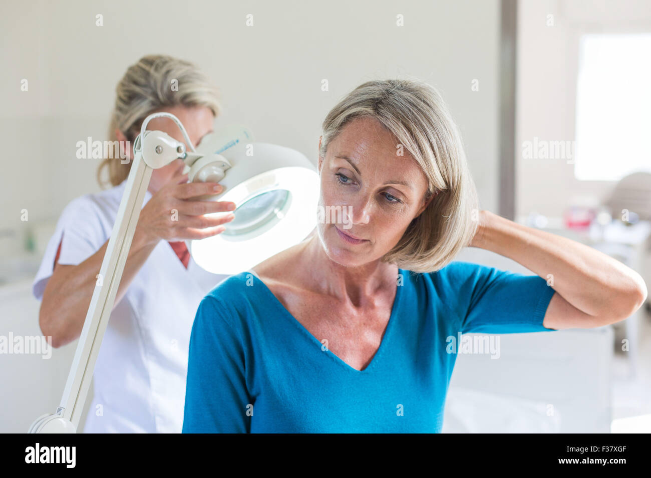 Doctor examining the skin of a woman Stock Photo - Alamy