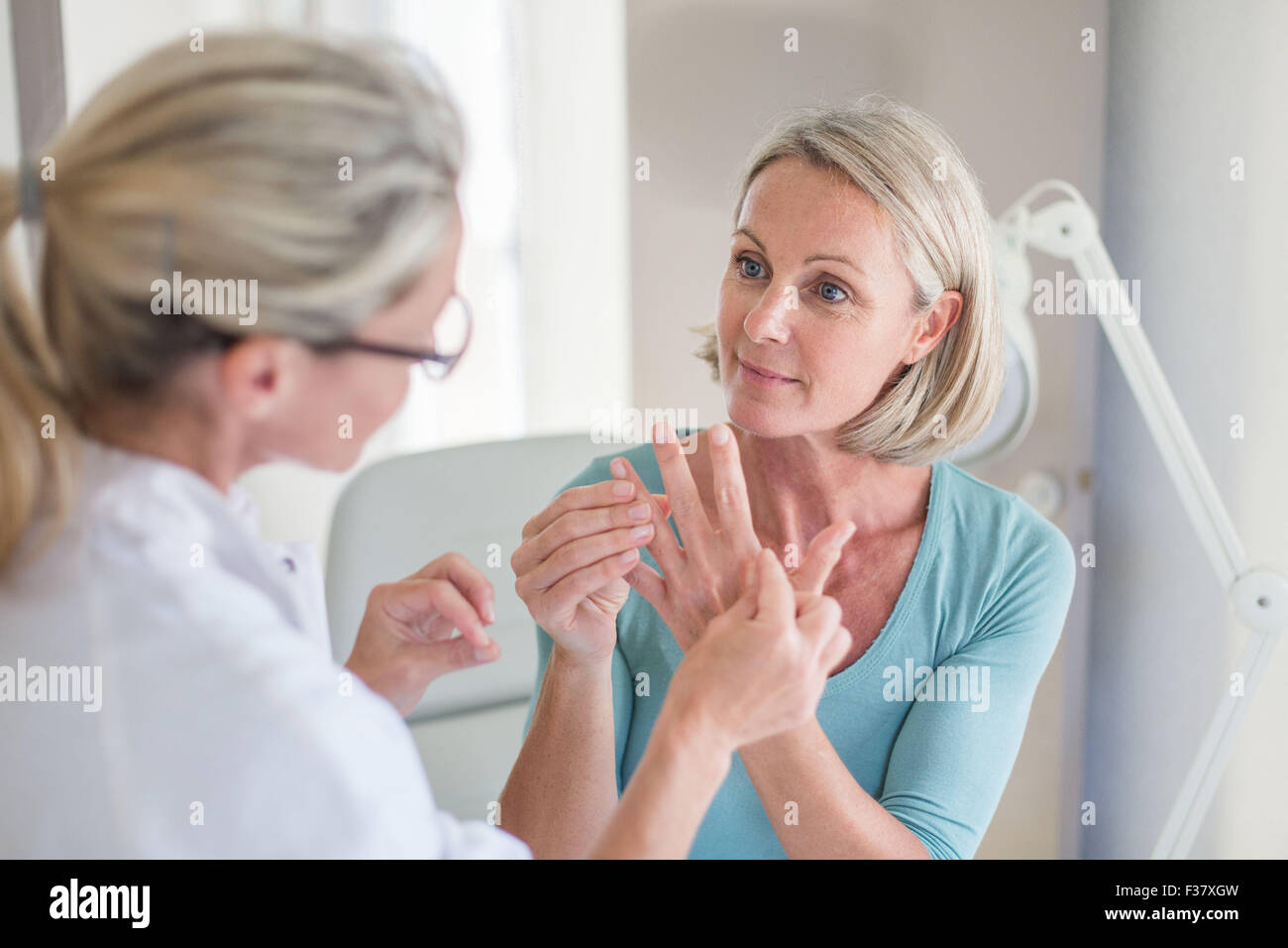 Doctor examining hand of a patient Stock Photo - Alamy