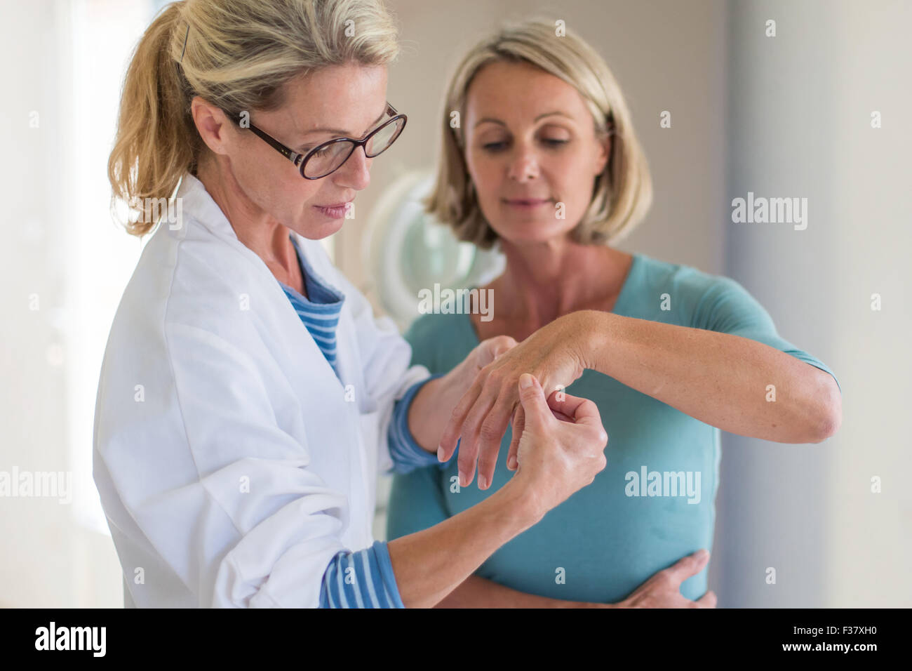 Doctor examining hand of a patient Stock Photo - Alamy