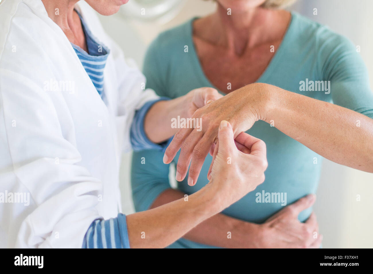 Doctor examining hand of a patient Stock Photo - Alamy