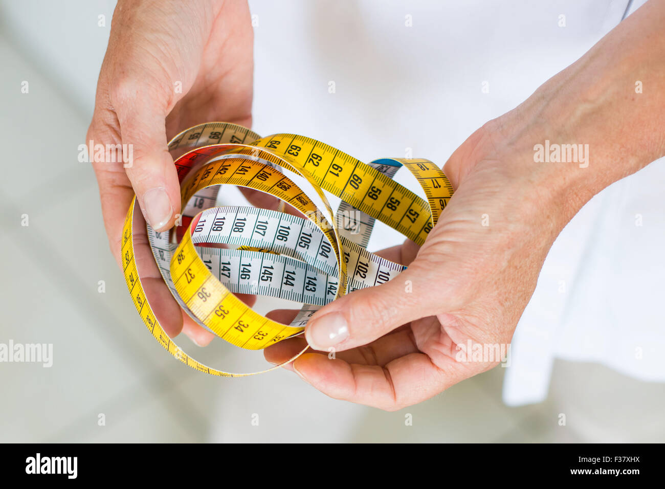 Woman holding tape measure Stock Photo - Alamy