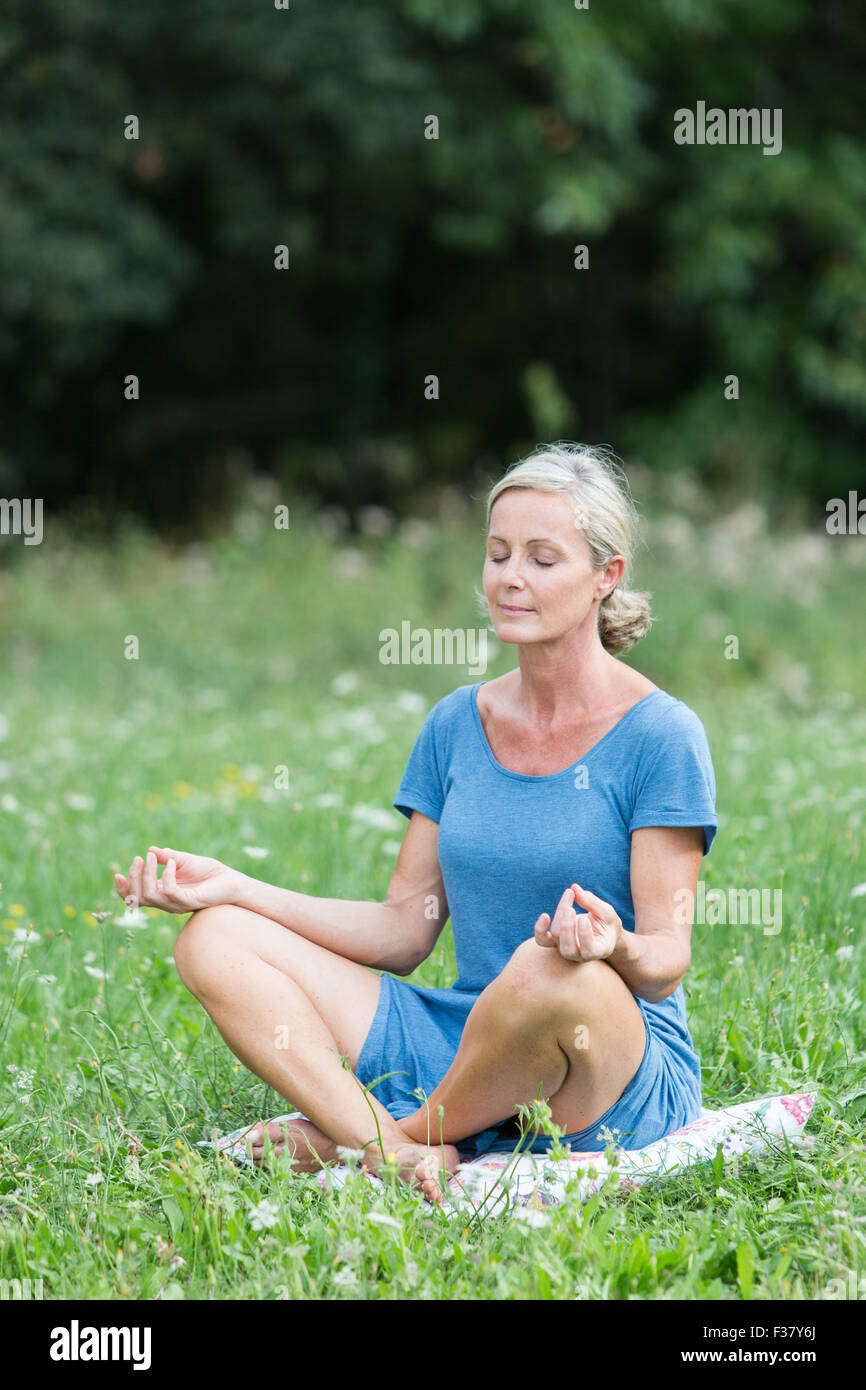 Woman sitting in the lotus position Stock Photo - Alamy
