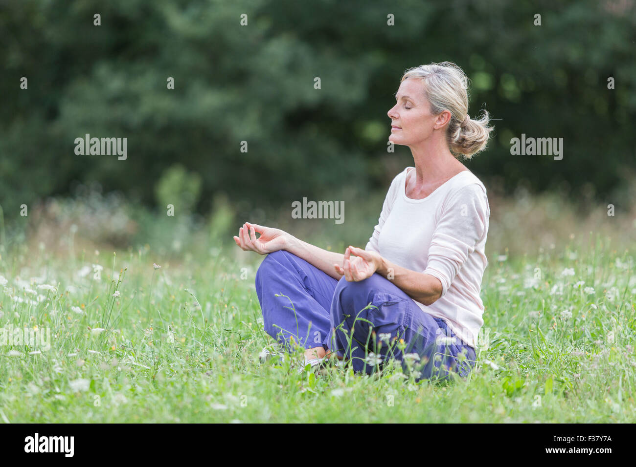 Woman sitting in the lotus position Stock Photo - Alamy