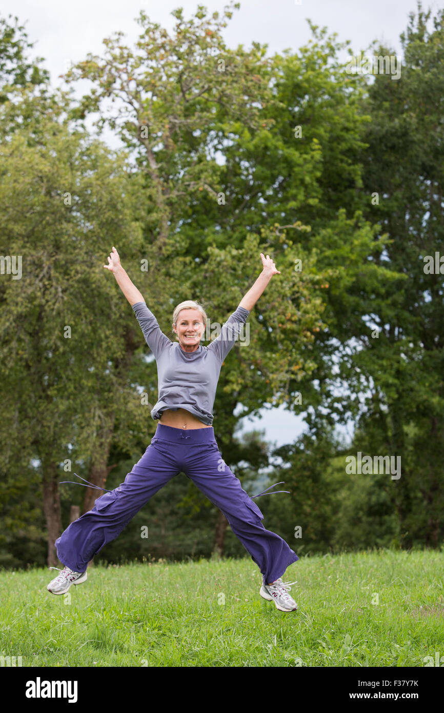 Woman jumping on grass Stock Photo - Alamy