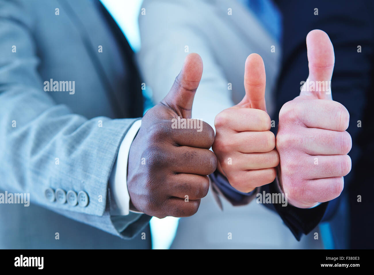Three business people showing thumb up gesture Stock Photo - Alamy