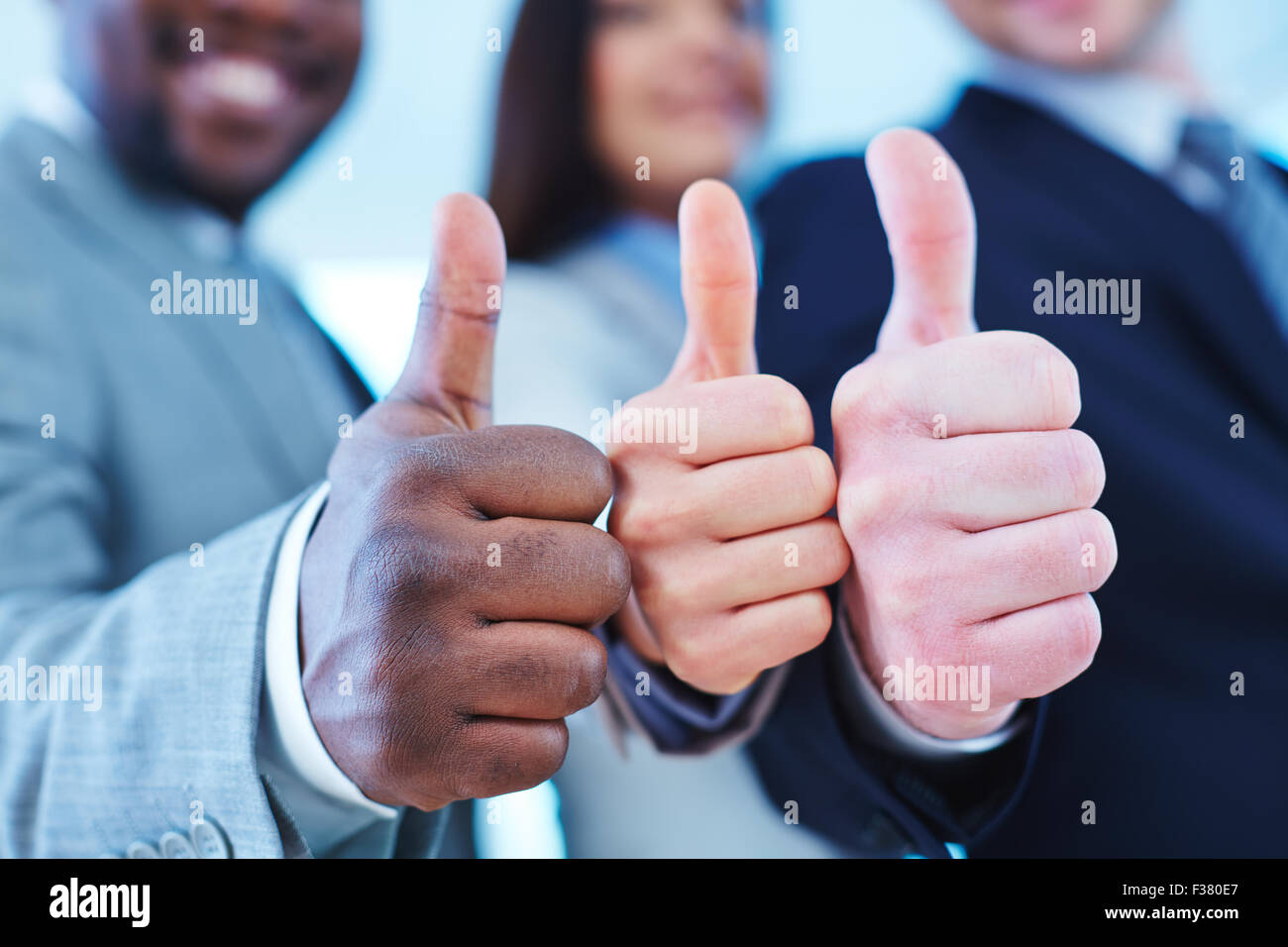 Thumb up gesture shown by group of employees Stock Photo - Alamy