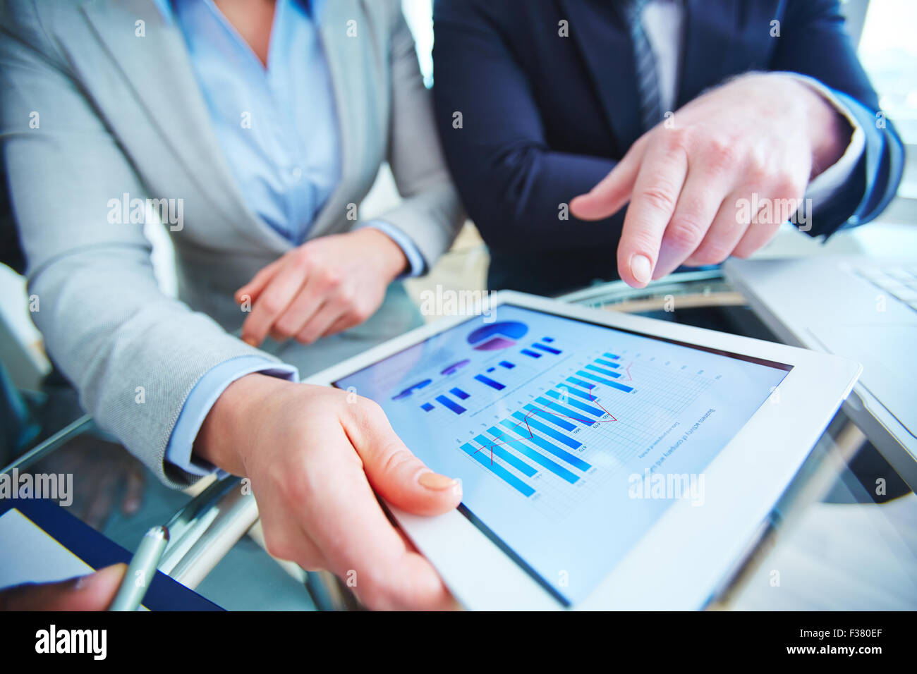 Employees with touchpad consulting about review of marketing Stock ...