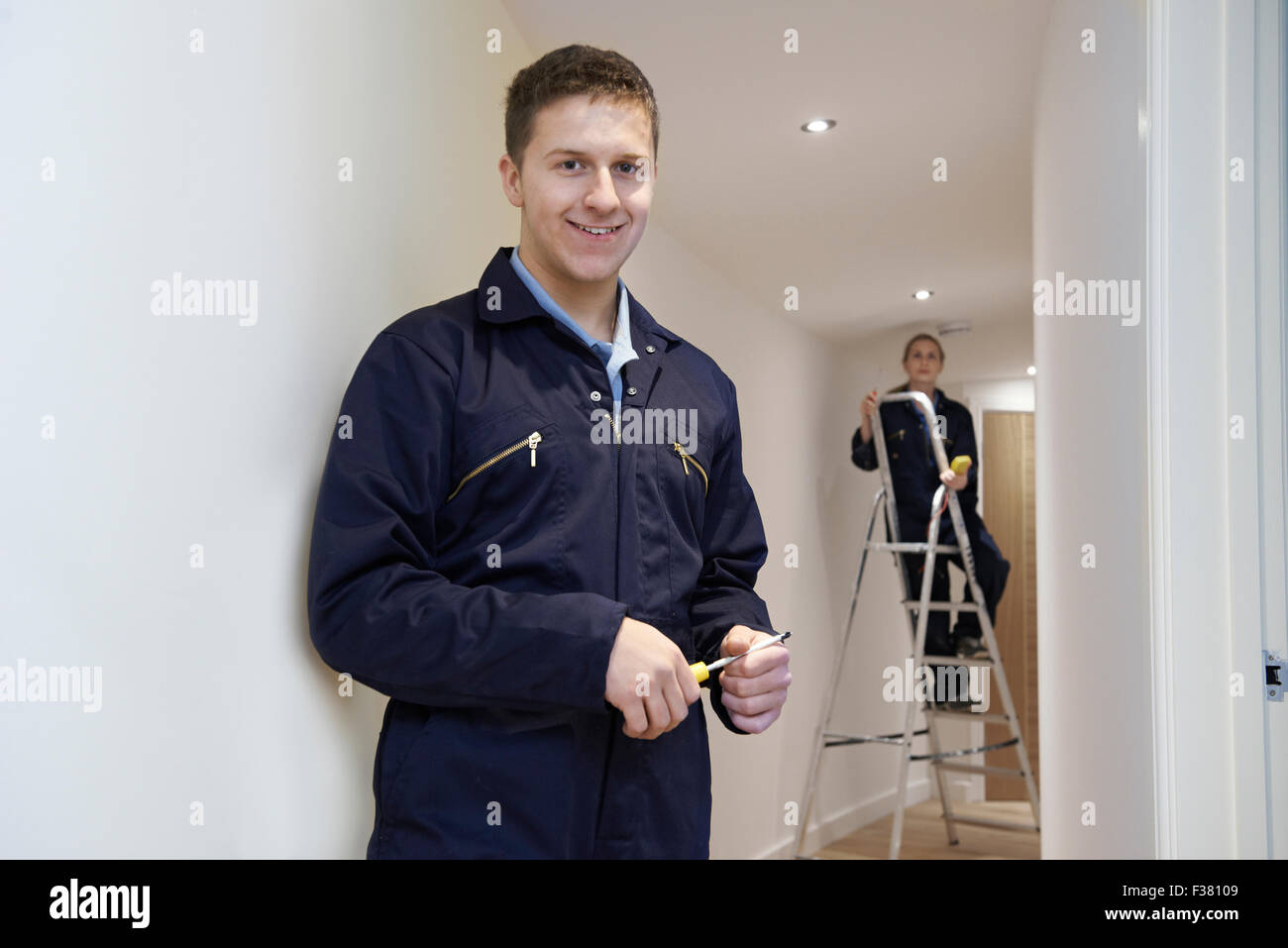 Electricians Installing Ceiling Lights In Domestic Home Stock Photo - Alamy