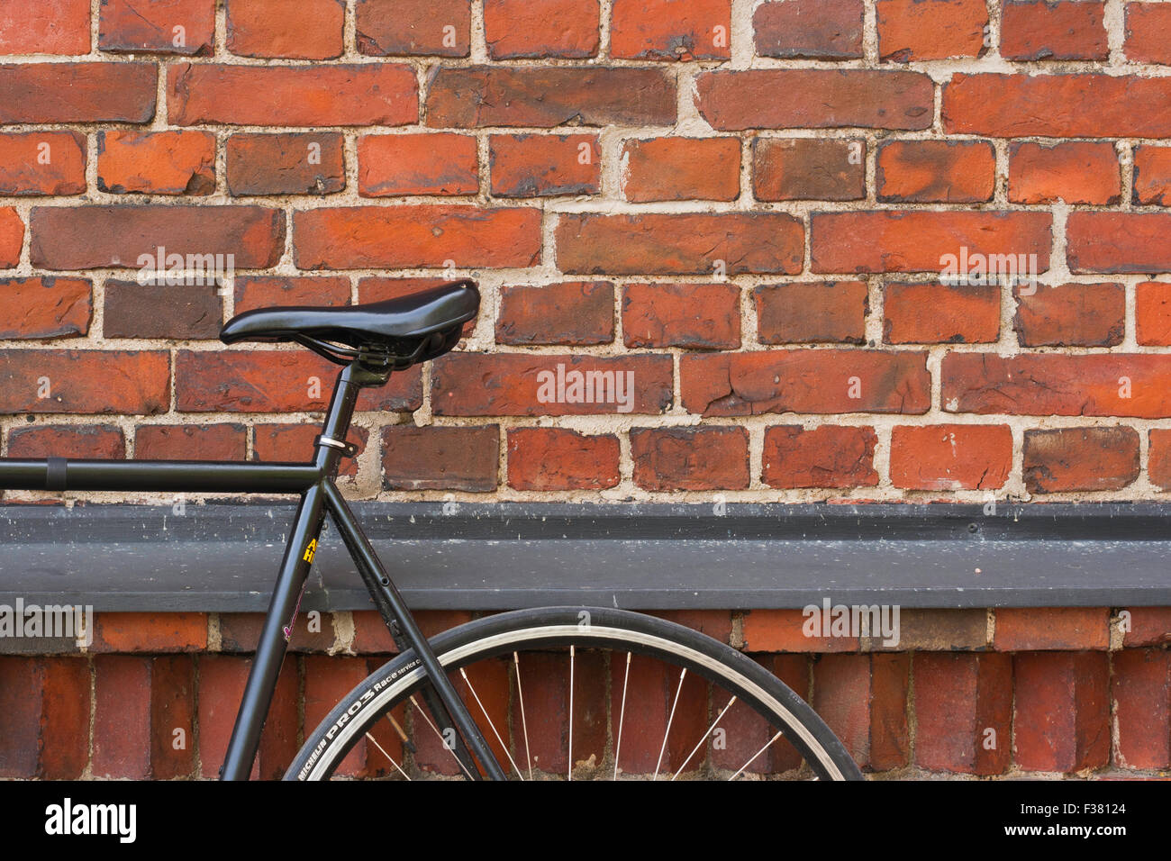Bicycle in front of a brick wall Stock Photo - Alamy