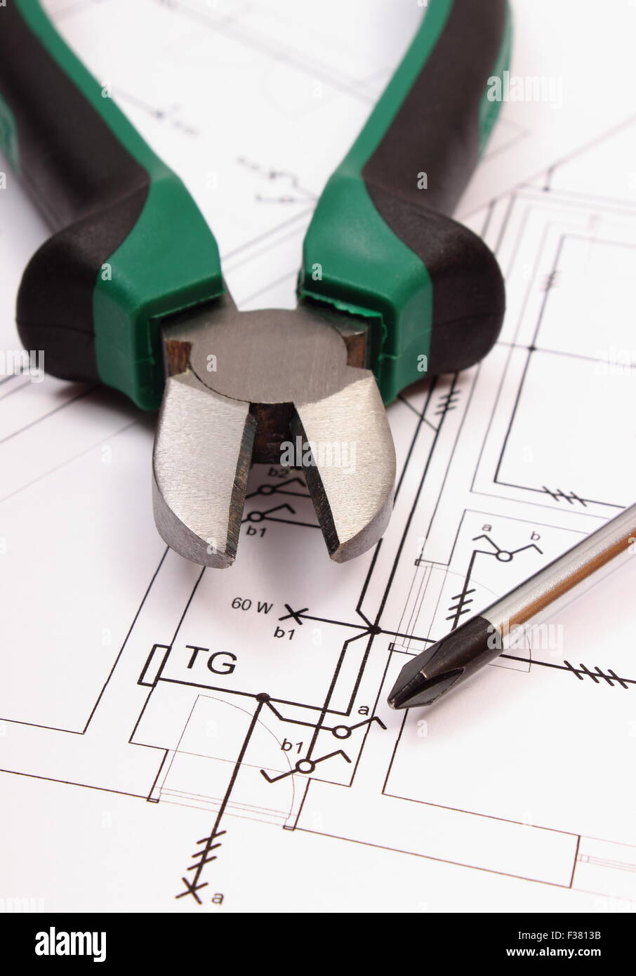 Metal pliers and screwdriver on electrical construction drawing of ...