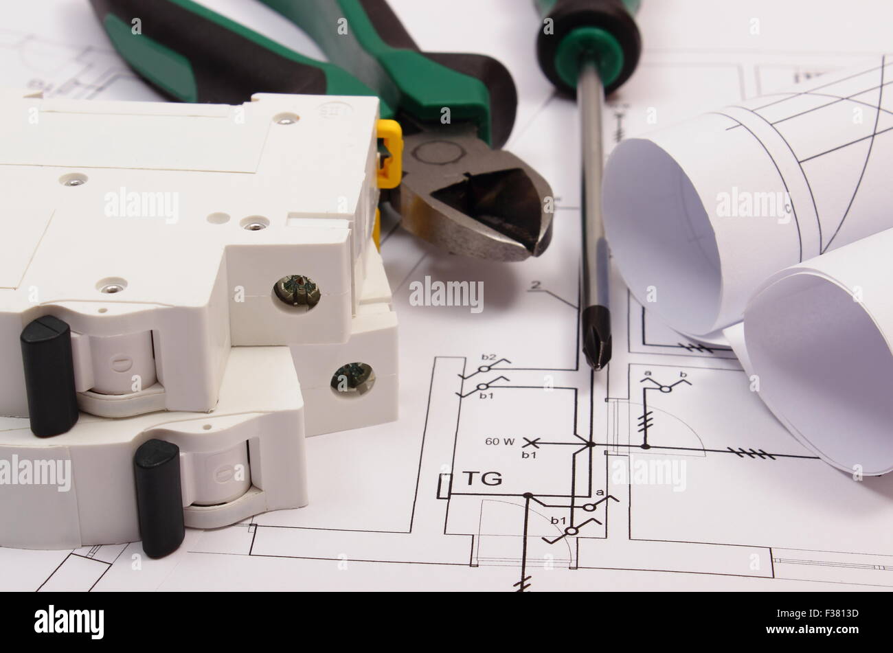 Metal pliers, screwdriver, electric fuse and rolls of diagrams on ...