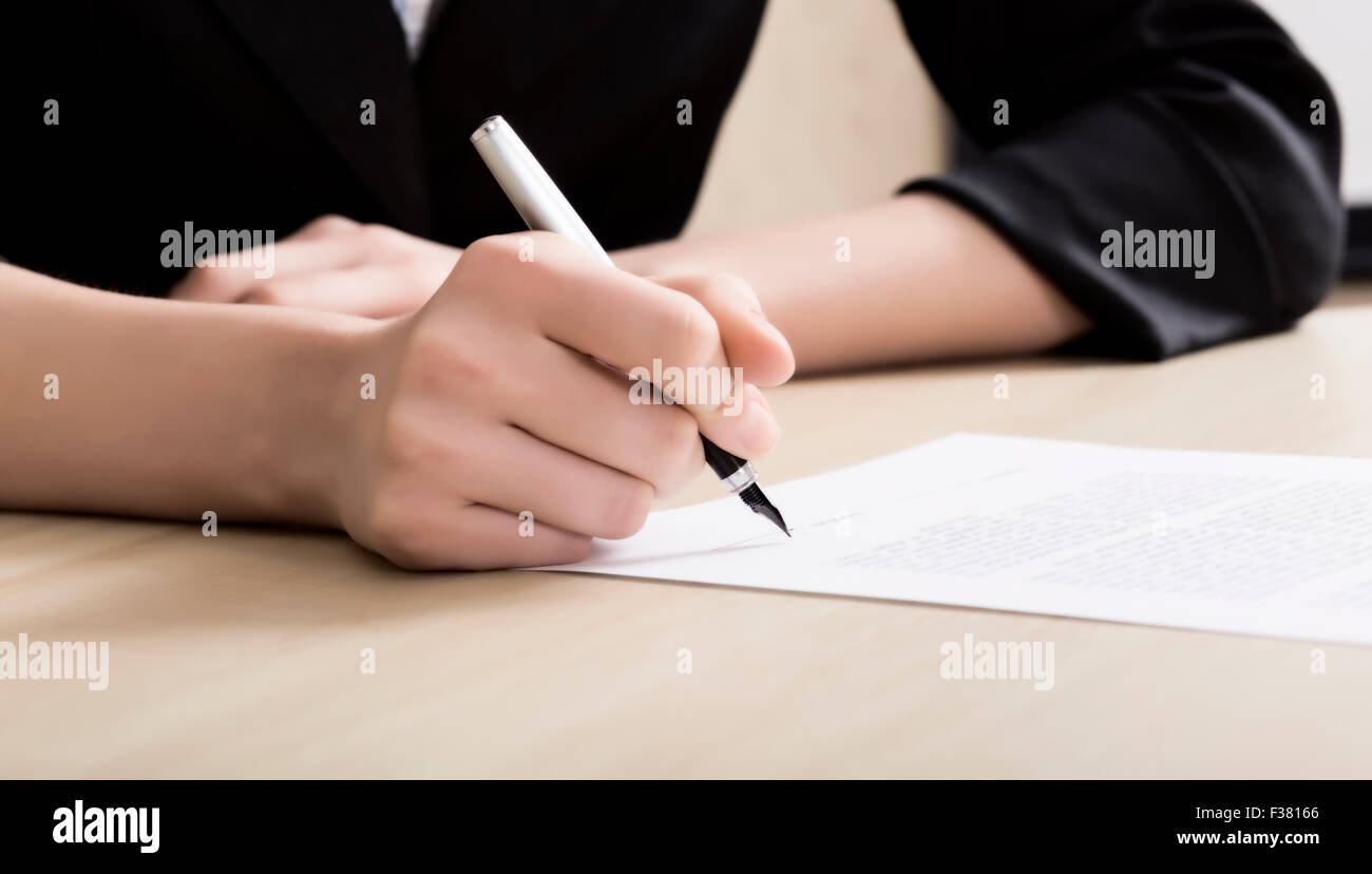 Female businessperson signs contract Stock Photo - Alamy