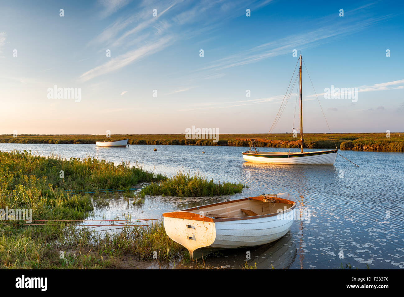 Boats at high tide on salt marshes at Blakeney on the north Norfolk ...