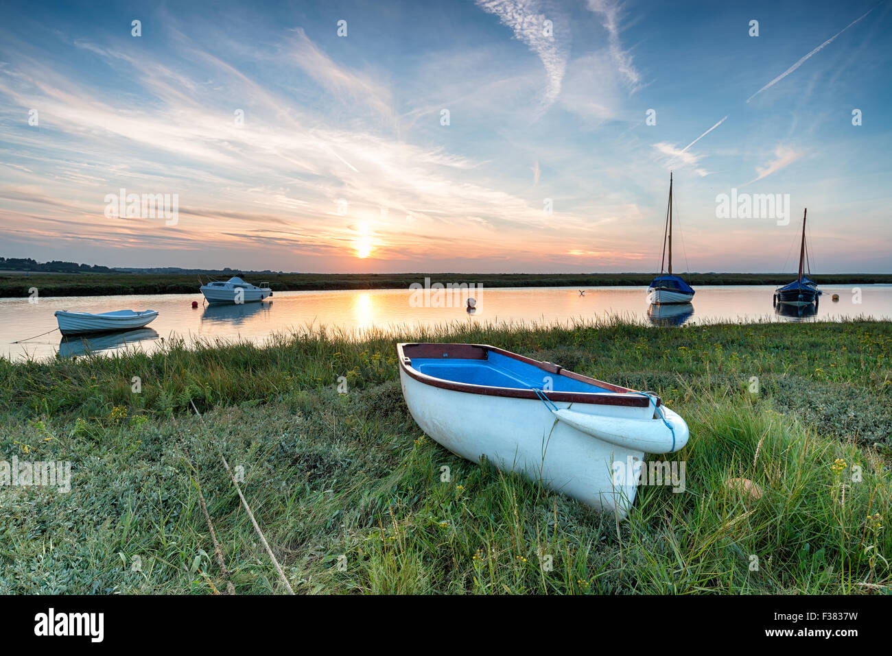Sunset over boats on the salt marshes at Blakeney on the north coast of ...