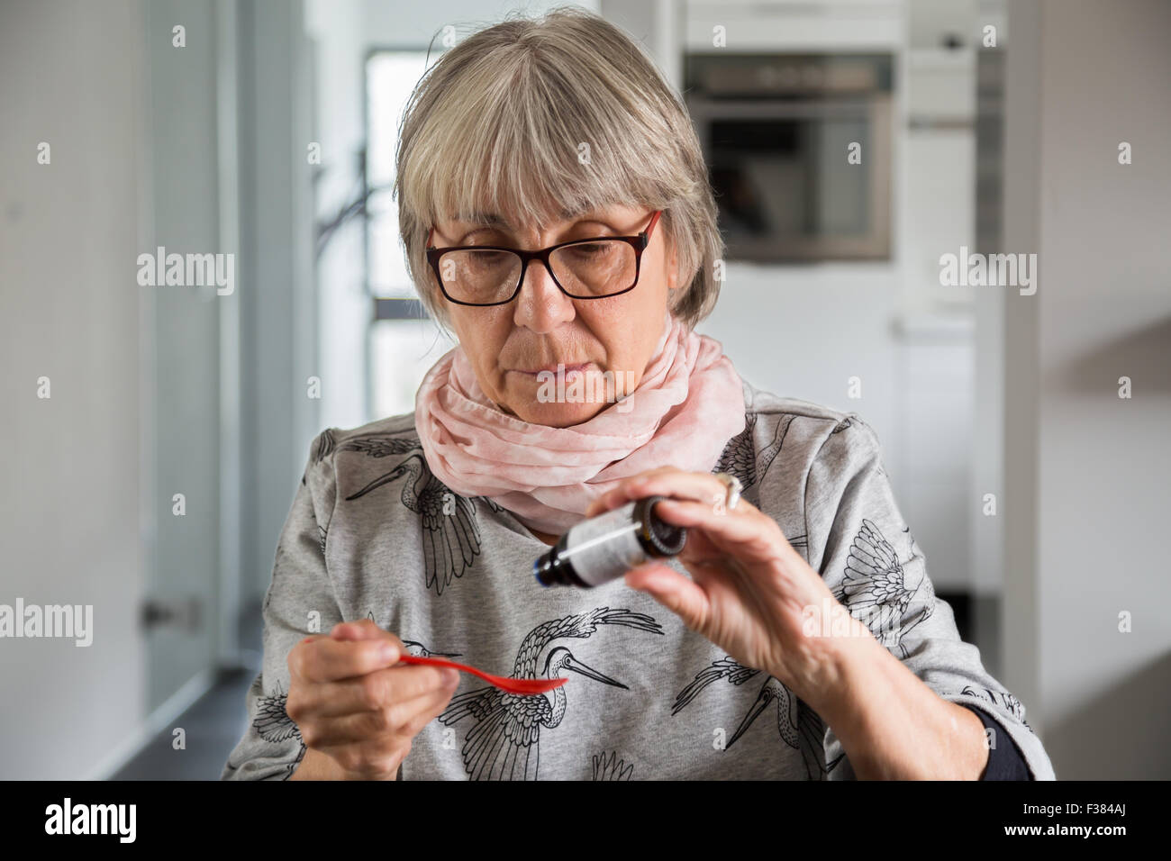 Senior woman drip medication on spoon Stock Photo - Alamy