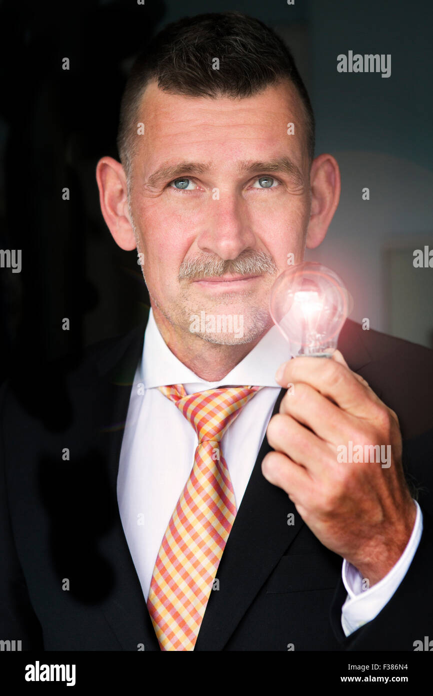 man holding an illuminated lightbulb in his hand Stock Photo - Alamy