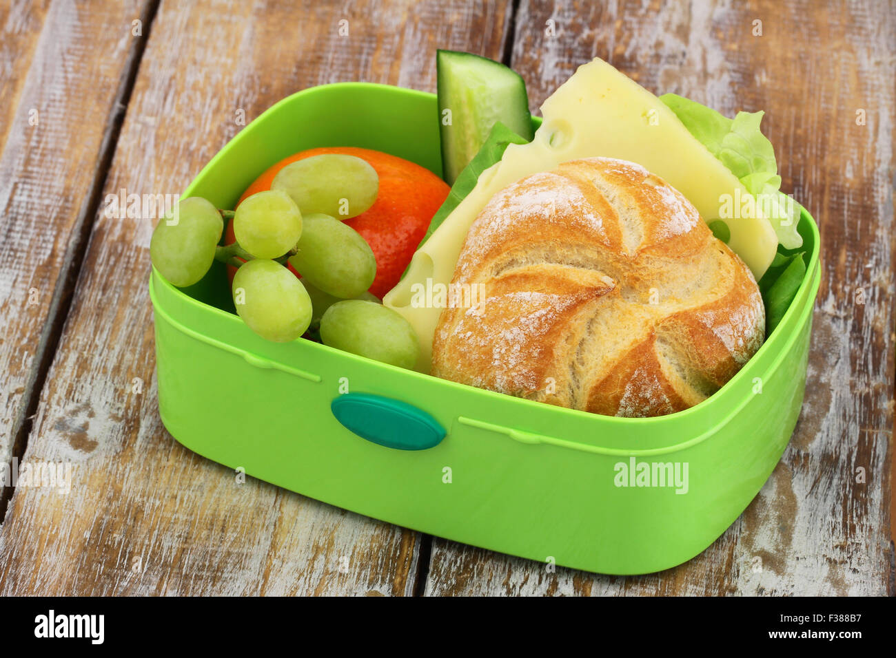 Lunch box consisting of cheese sandwich, grapes, mandarines and ...