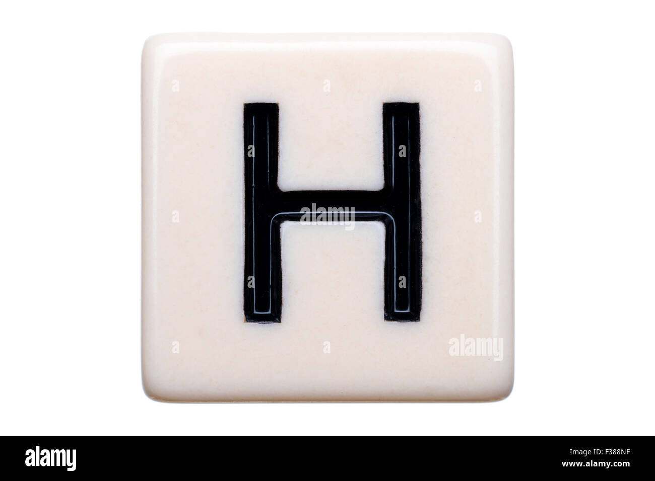 A macro shot of a game tile with the letter H on it on a white ...