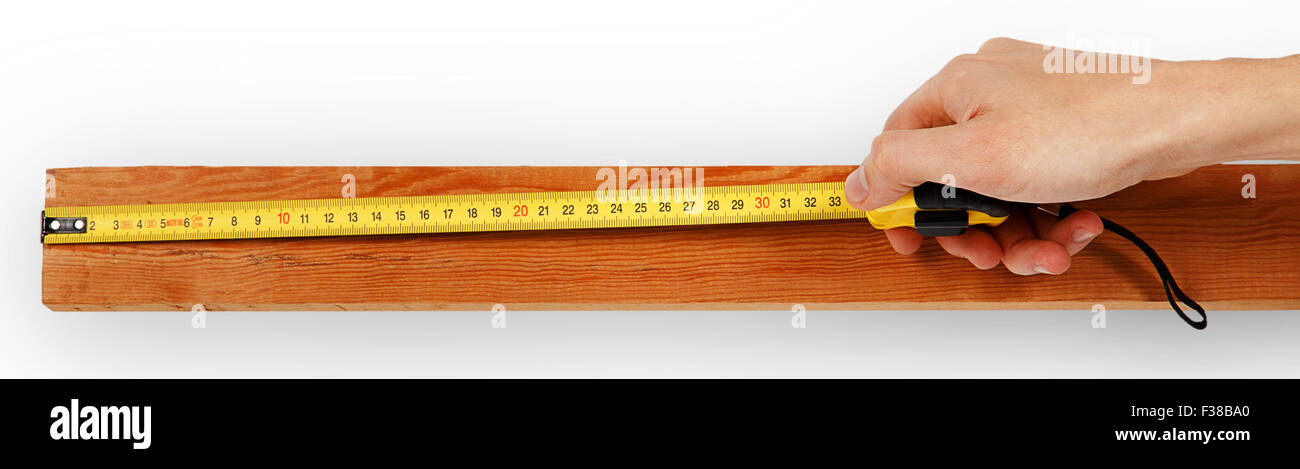 Close-up of a male hand using measuring tape on wooden board isolated ...
