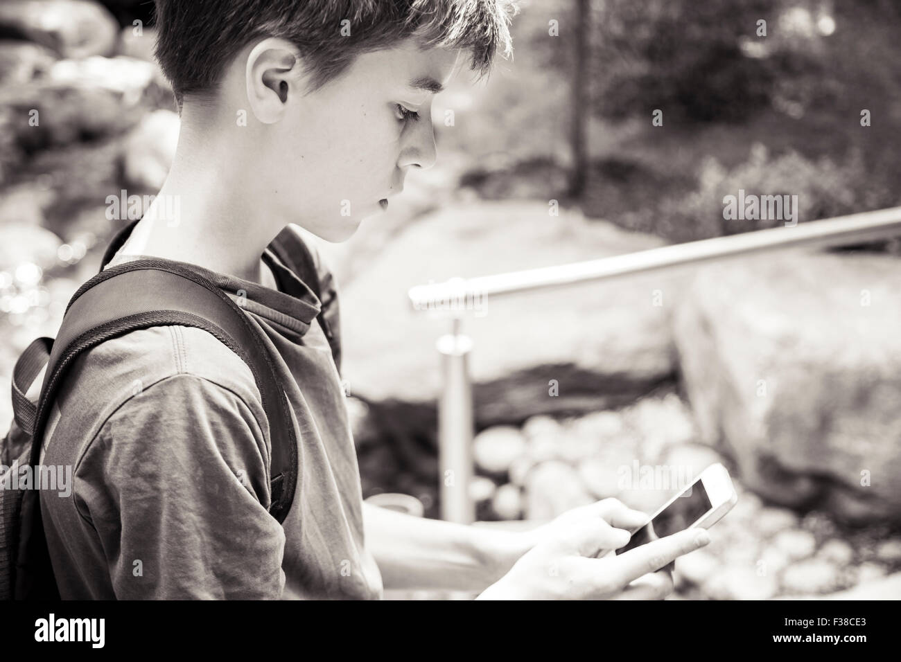 teenage boy is looking on a smart phone Stock Photo - Alamy