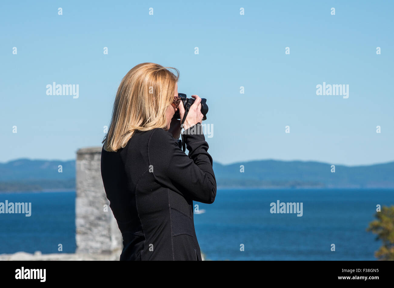 Beautiful Blond woman taking photographs outside near the water Stock ...