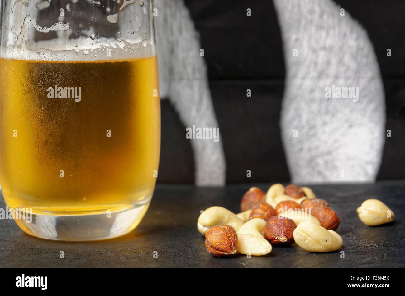 pouring beer with nuts and cashew nuts Stock Photo - Alamy
