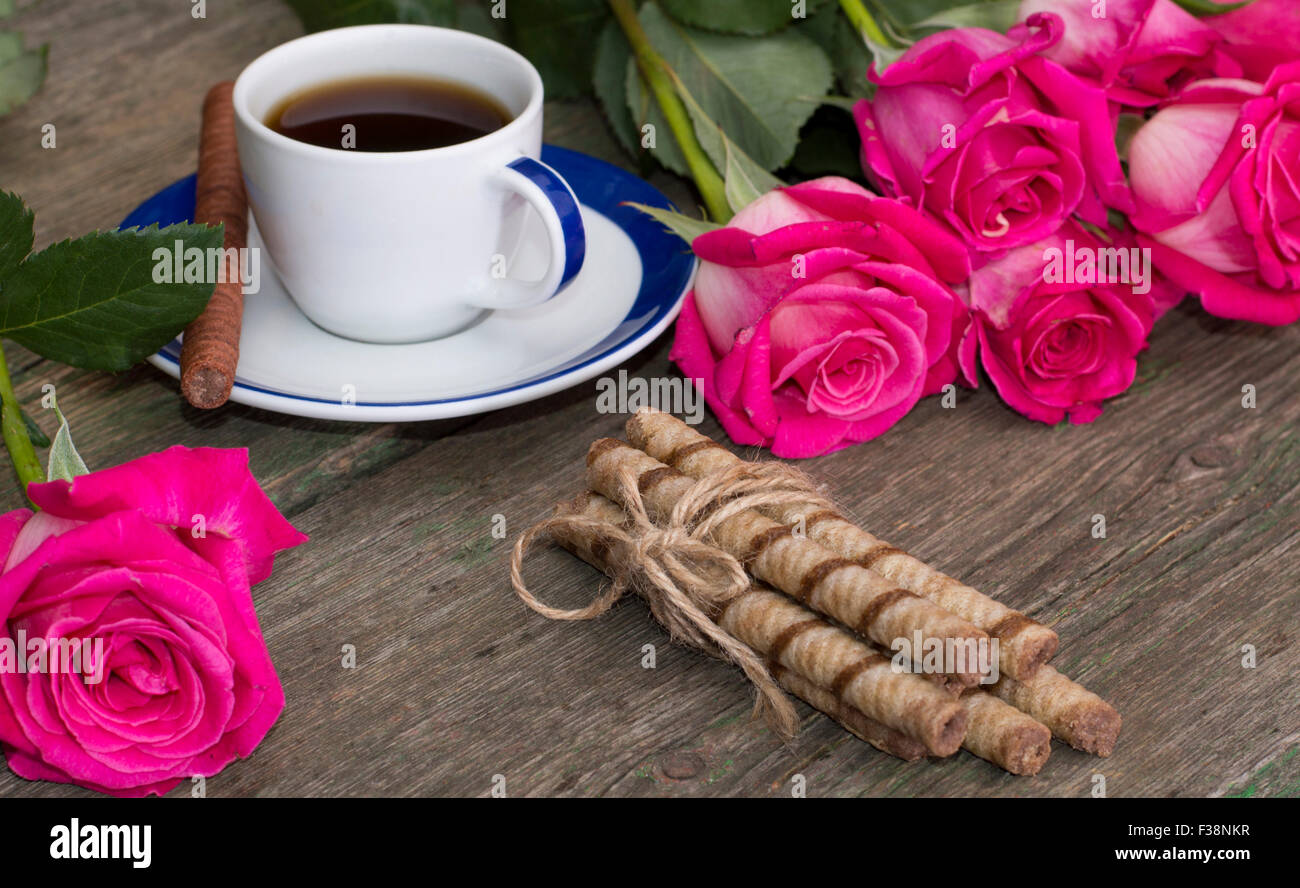 still life bouquet of roses, cup of black coffee, linking of cookies ...