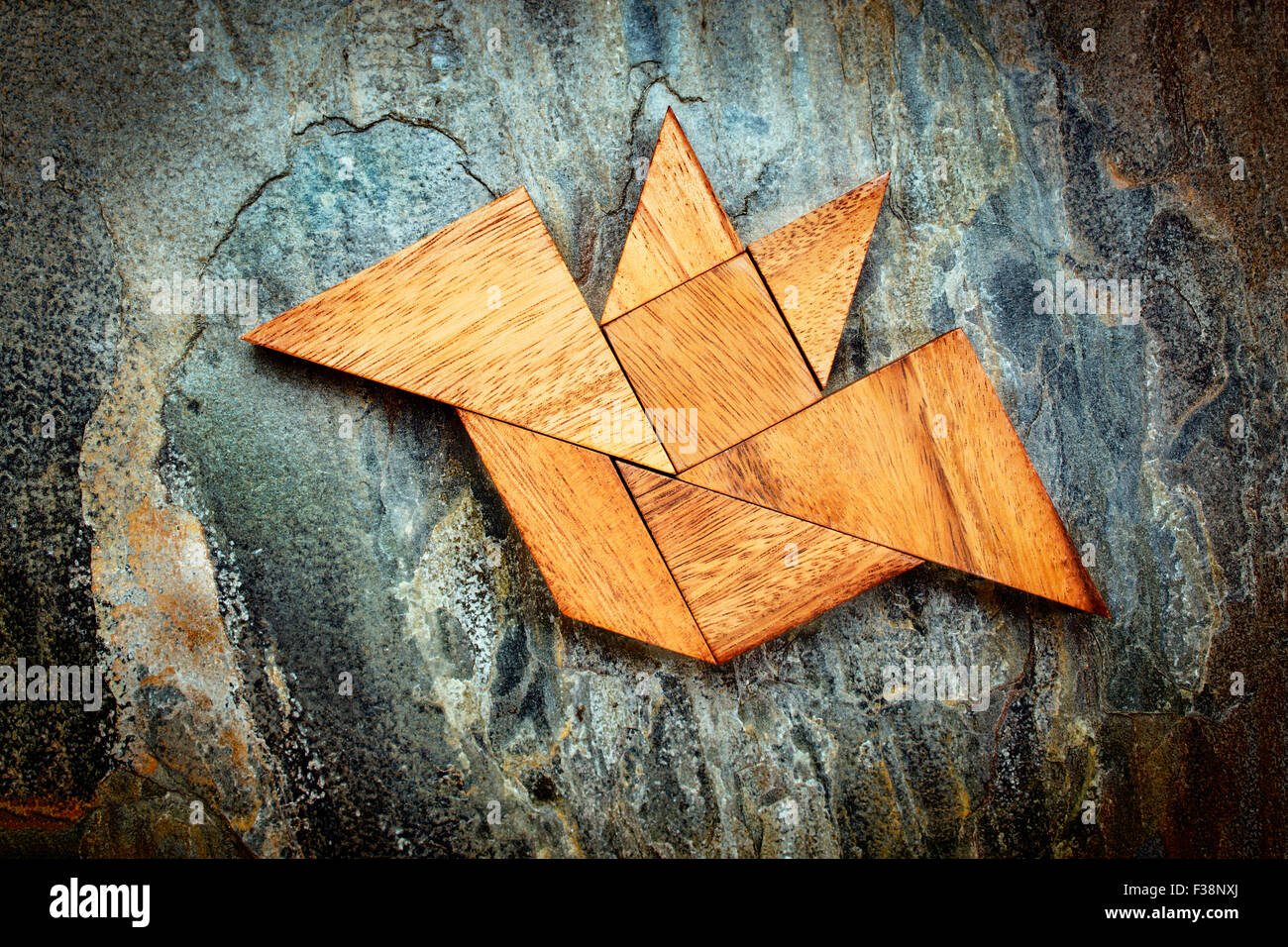 abstract picture of a flying bat built from seven tangram wooden pieces ...