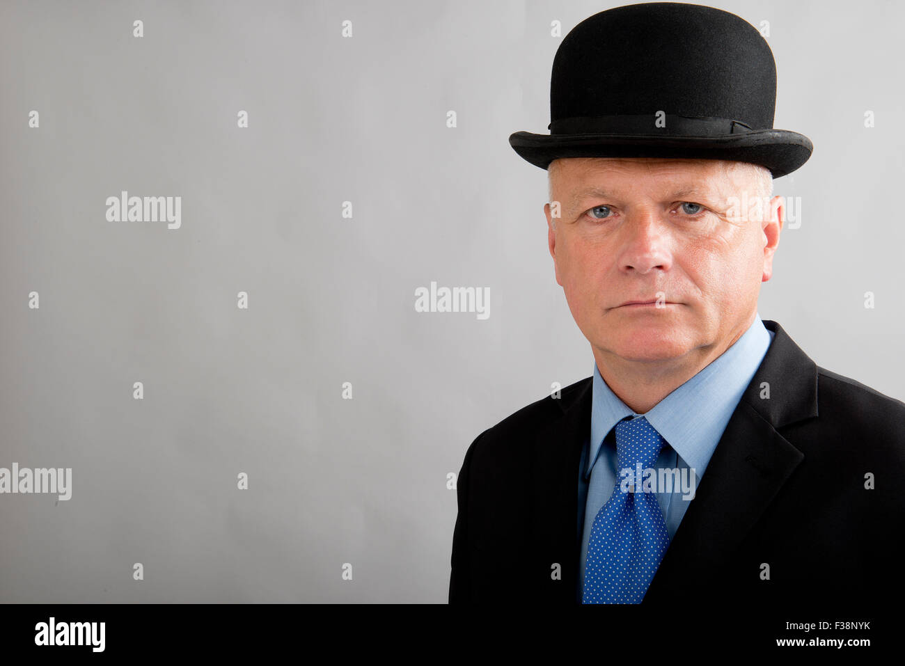 A very serious looking businessman, wearing a dark suit with matching ...