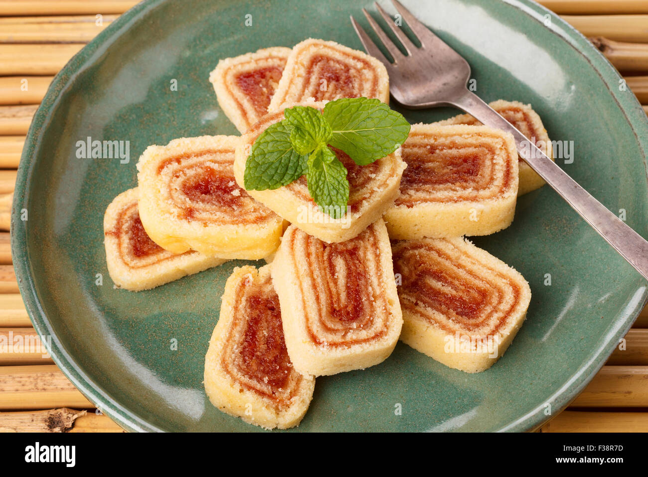 Bolo de rolo (swiss roll, roll cake) Brazilian dessert on green plate ...