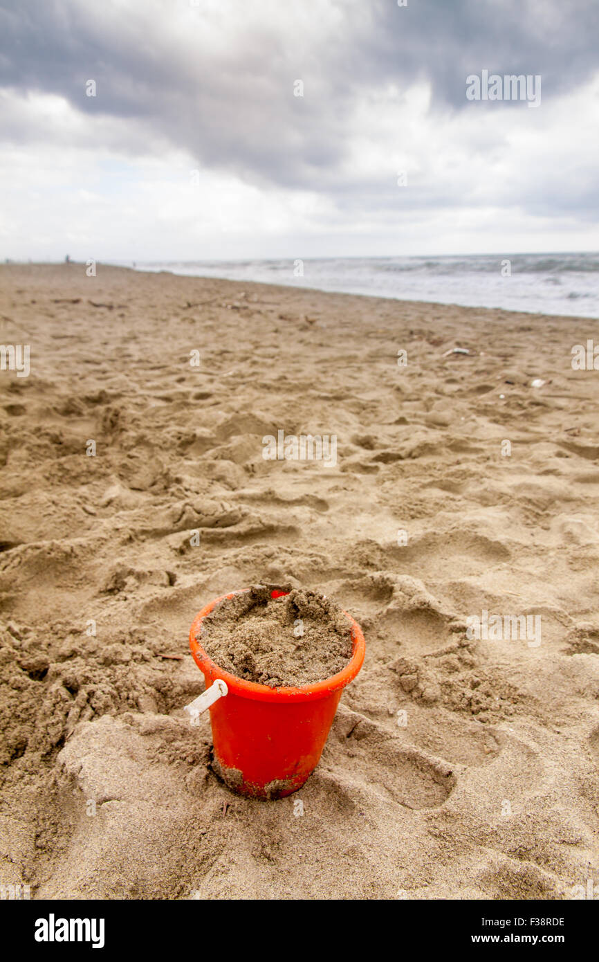 Bucket full of sand on the beach in a cloudy day Stock Photo - Alamy