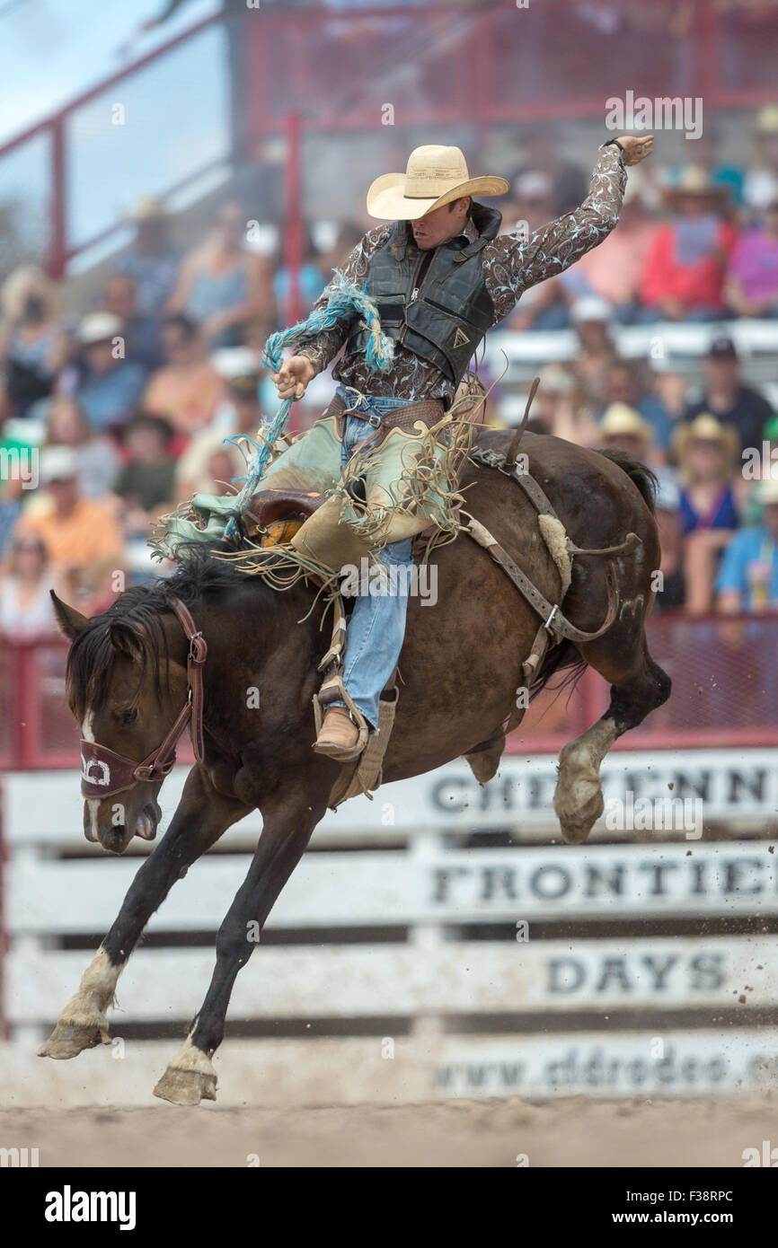A saddle bronc rider hangs on to the bucking bronco at the Cheyenne ...