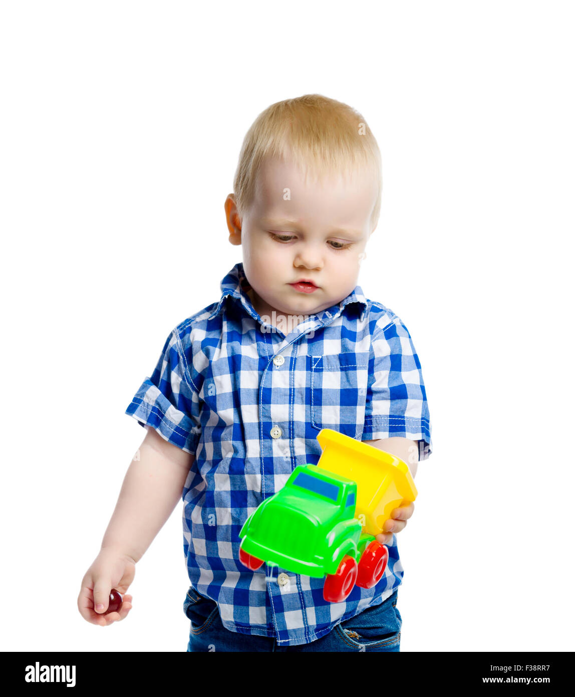 A little boy in checkered shirt plays with a toy car. White background ...