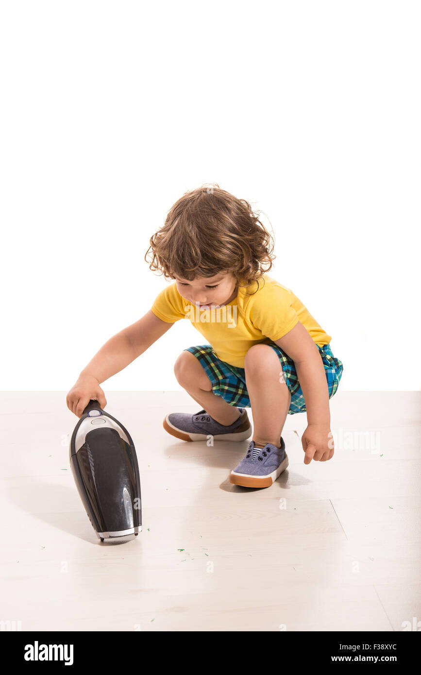 Toddler boy cleaning house with hand-held vacuum cleaner Stock Photo ...