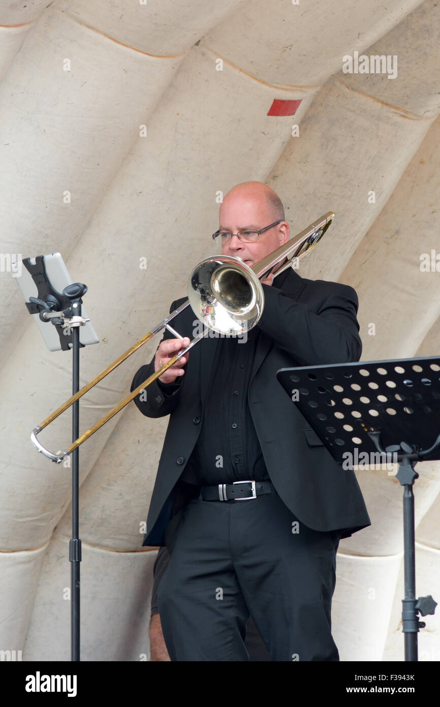 Musician playing a trombone on stage at the Castle Road Festival (free ...