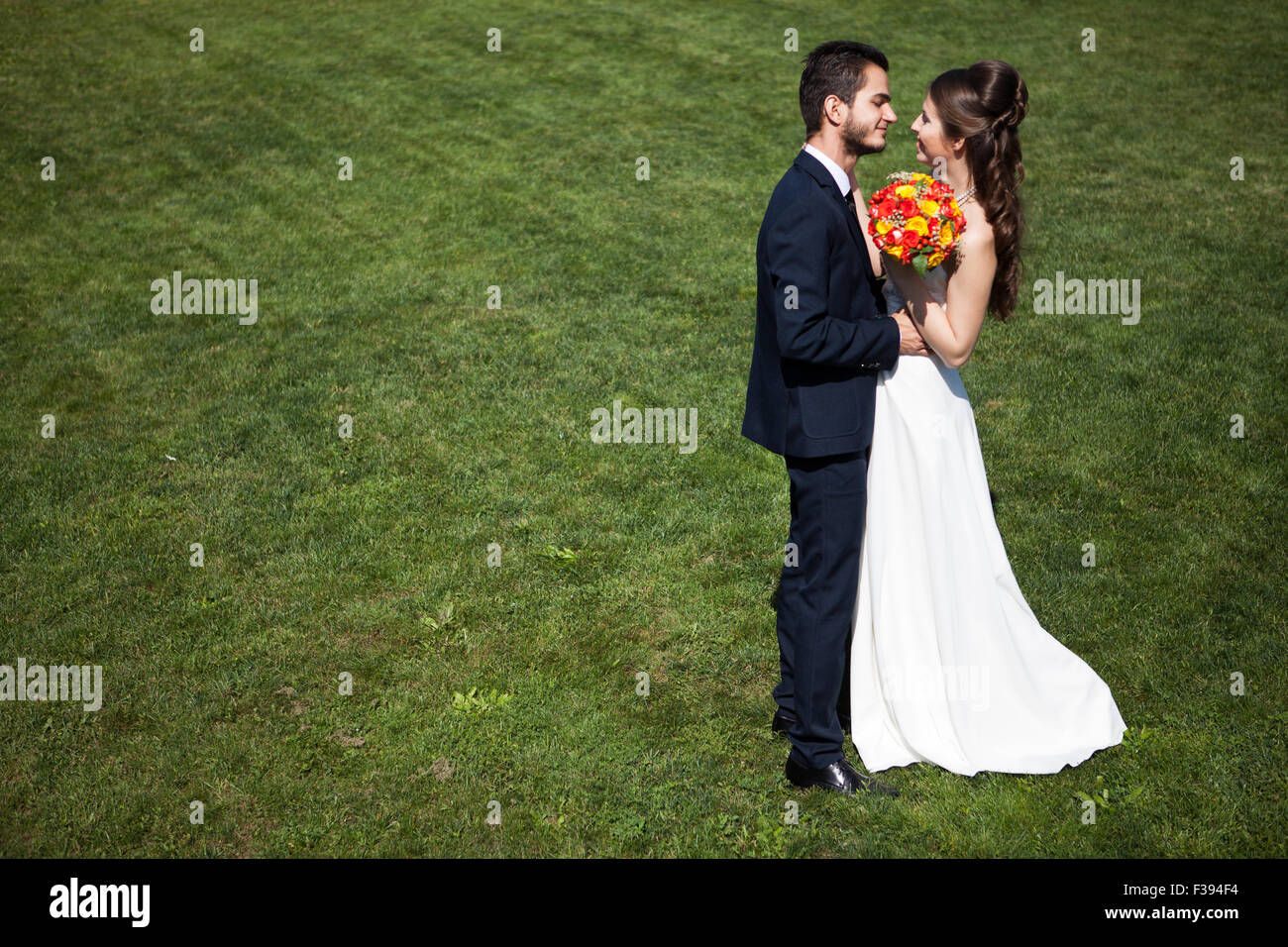Bride and groom on green grass background. Just married. Happy familly ...