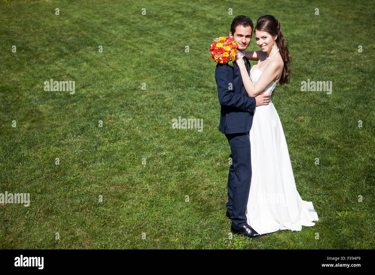 Bride and groom on green grass background. Just married. Happy familly ...