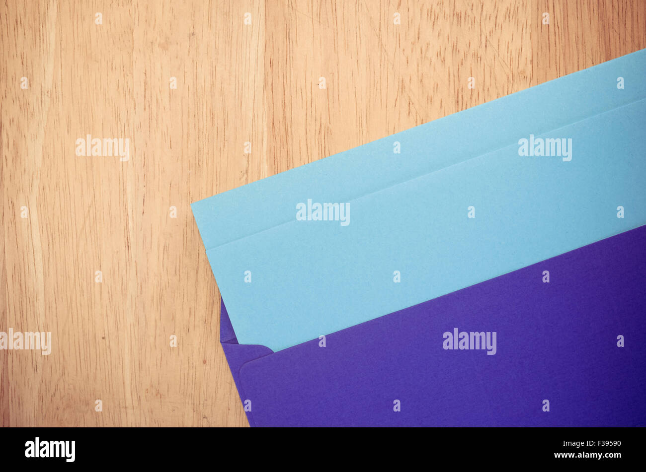 dark blue envelope and blue writing paper on a natural wood surface ...