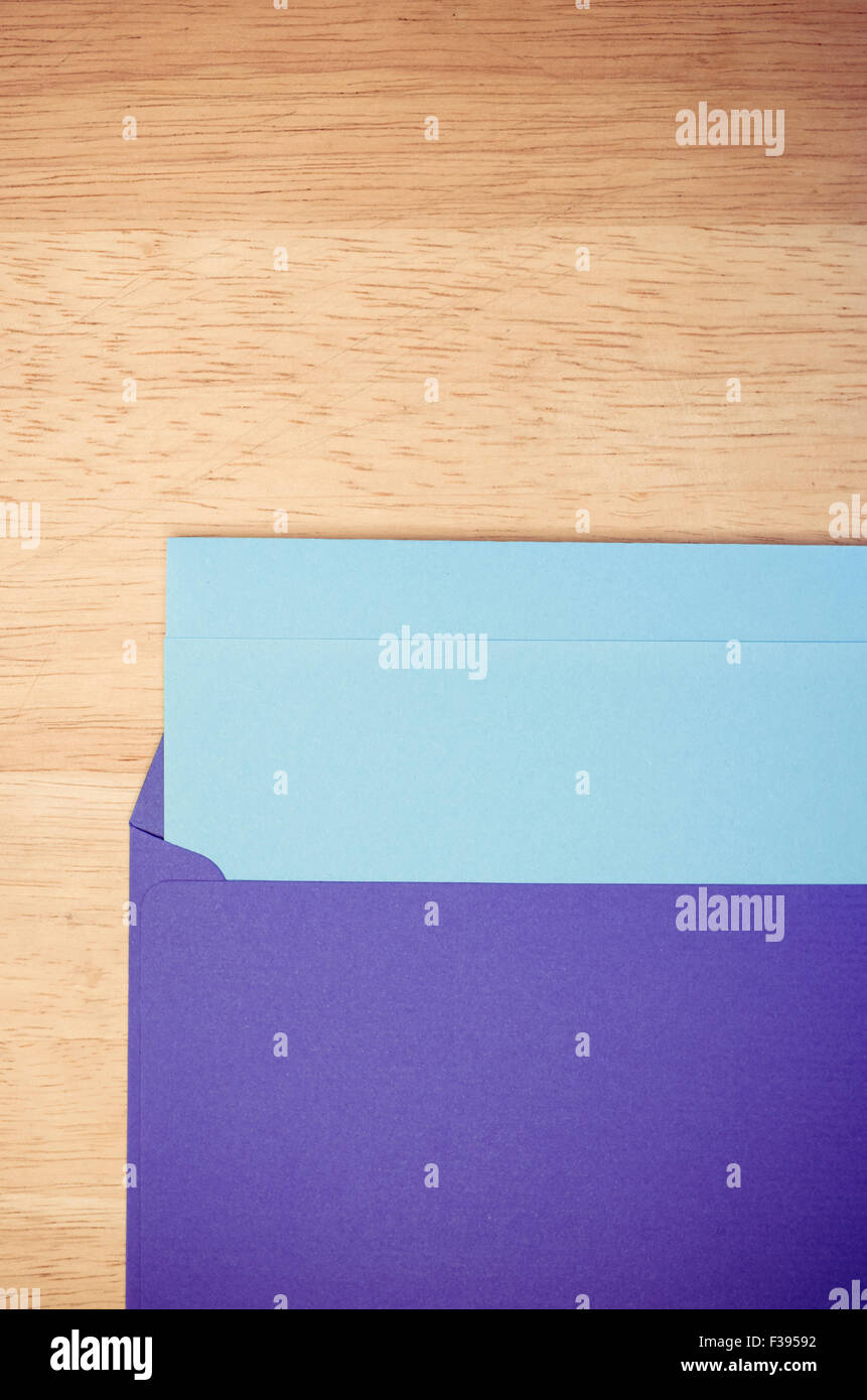 dark blue envelope and blue writing paper on a natural wood surface ...