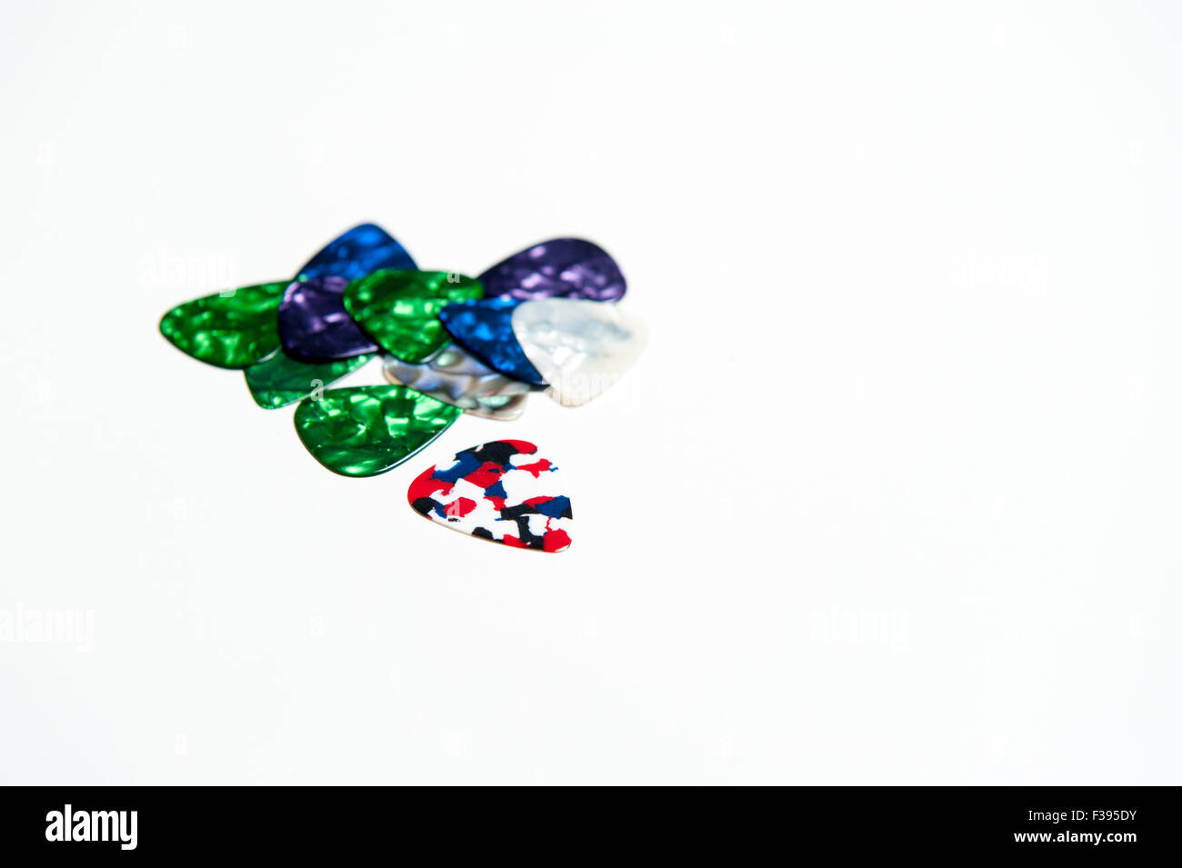 Many guitar picks plectrum in different colors on white background ...