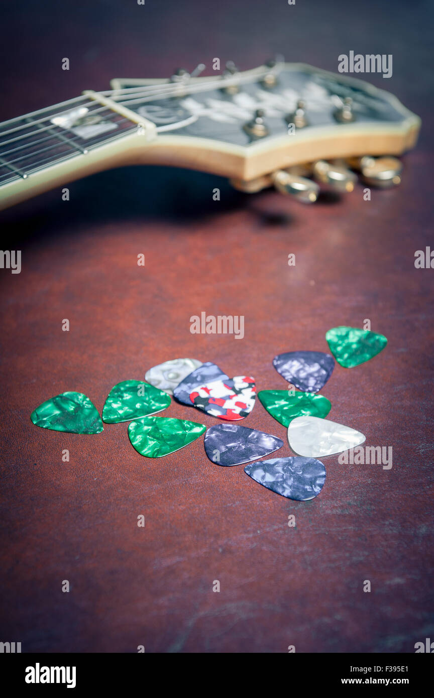 Many guitar picks plectrum in different colors with guitar head out of ...